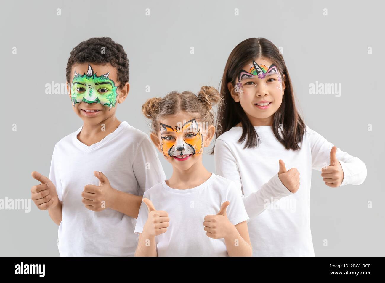 Funny children with face painting on light background Stock Photo - Alamy