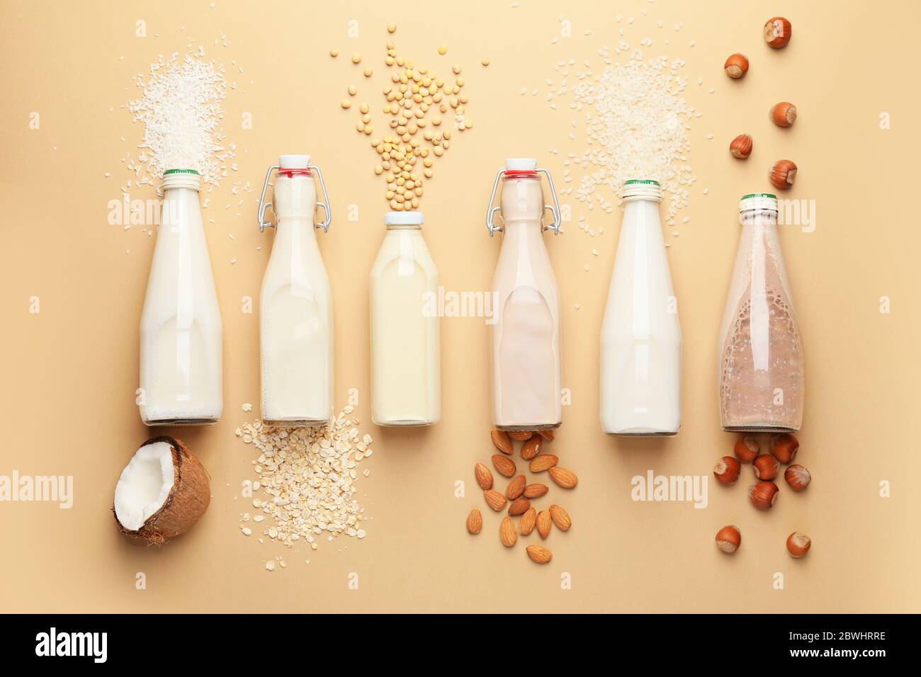 Bottles of different milk on color background Stock Photo - Alamy