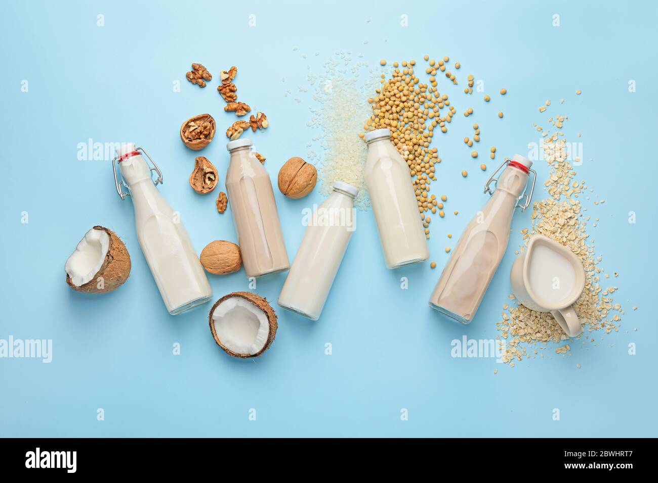 Bottles of different milk on color background Stock Photo - Alamy