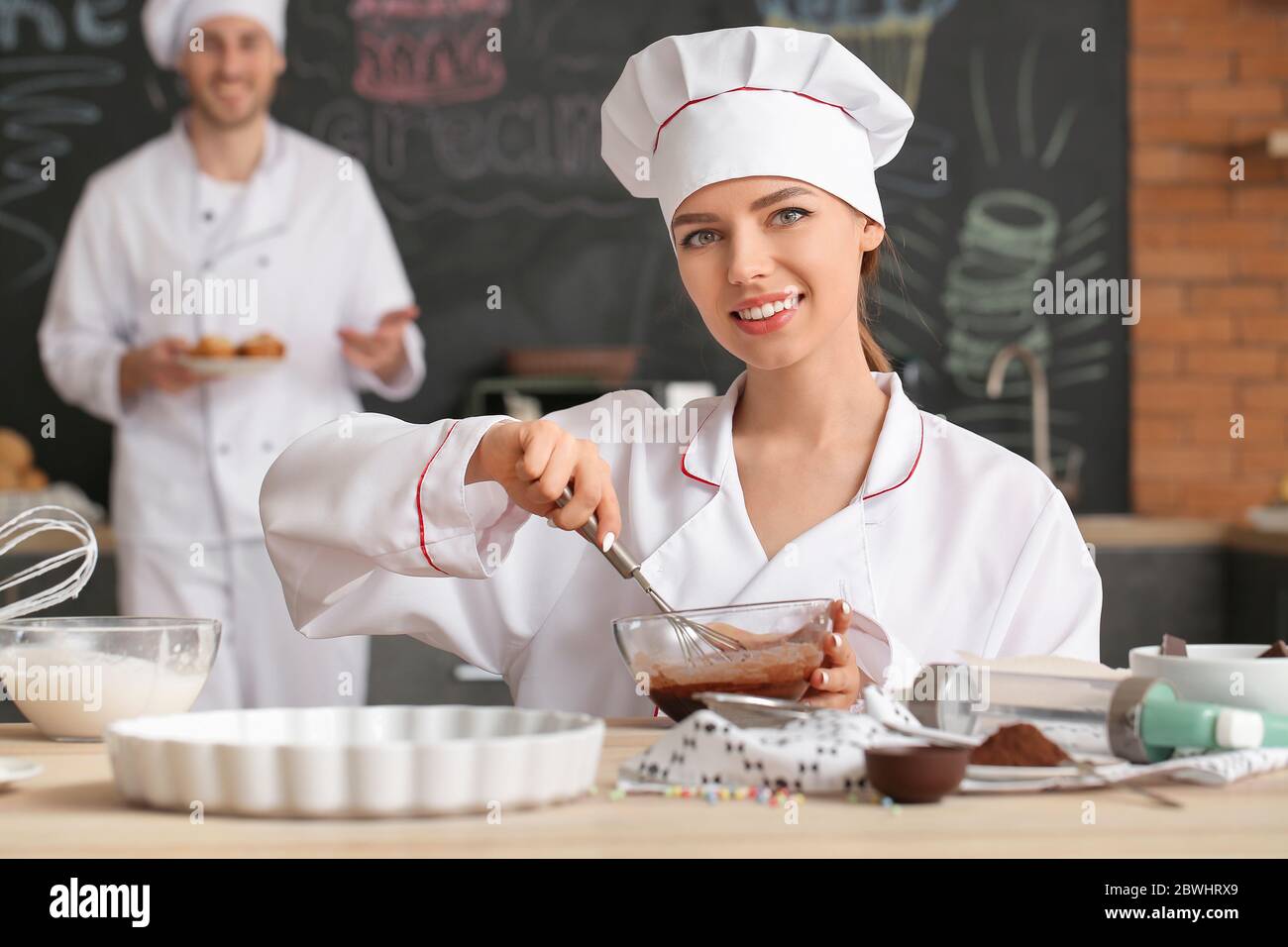 Female confectioner cooking tasty dessert in kitchen Stock Photo - Alamy