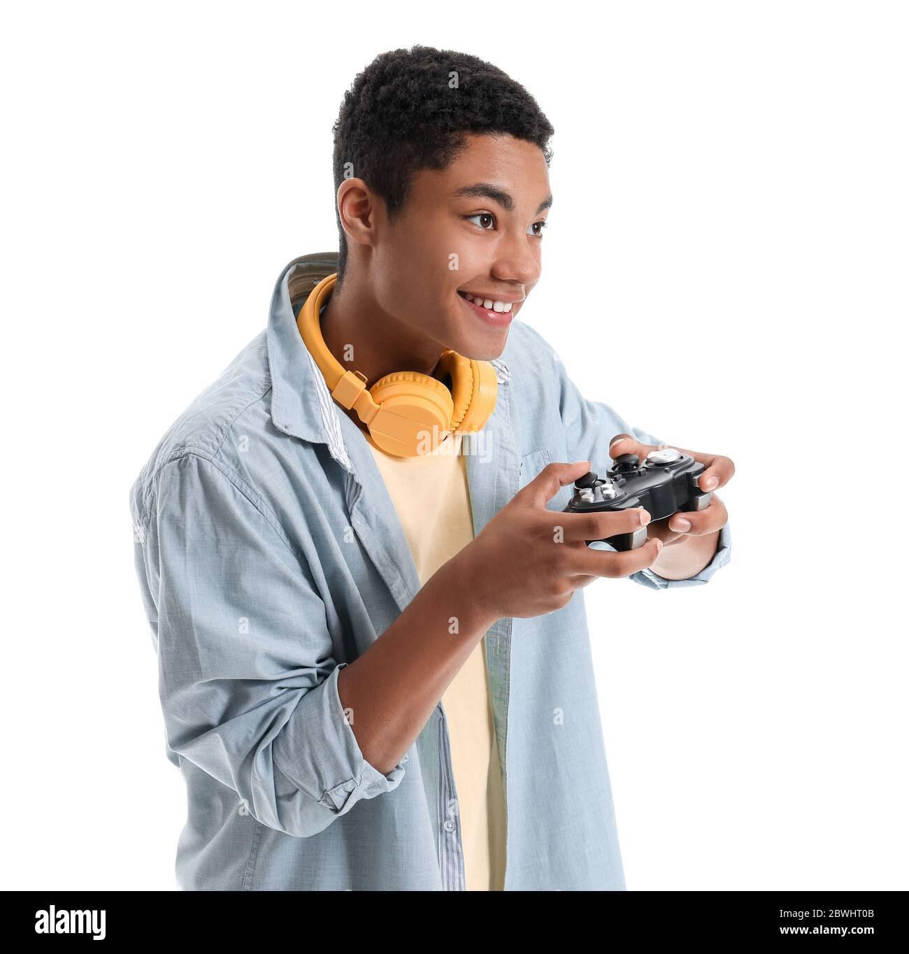 African-American teenage boy playing video game on white background ...