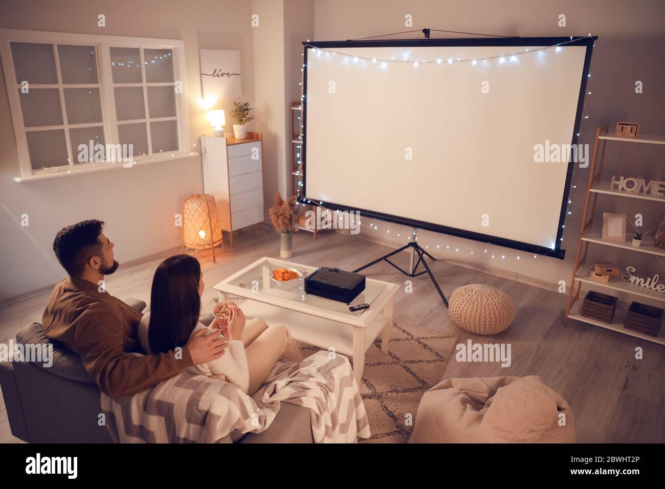 Young couple watching movie at home Stock Photo - Alamy