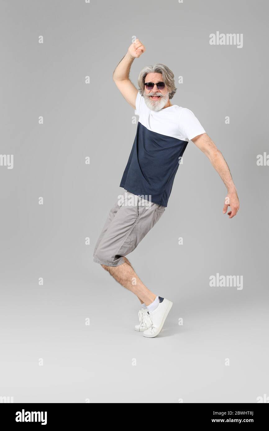 Cool senior man dancing against grey background Stock Photo - Alamy