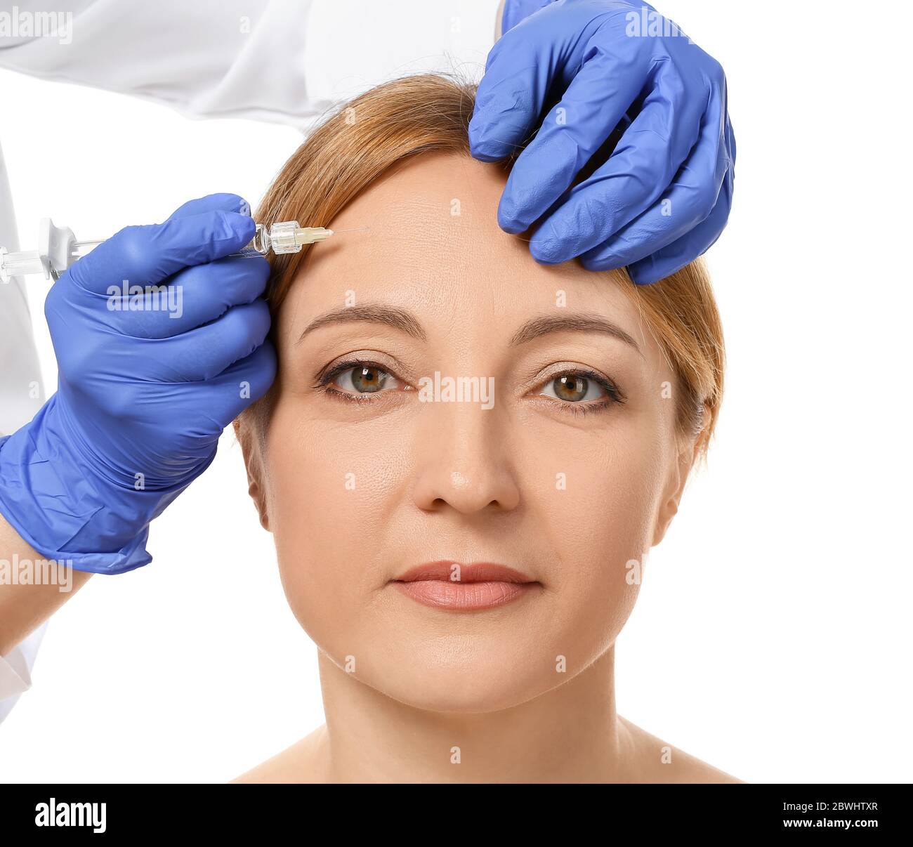 Woman receiving filler injection against white background Stock Photo ...
