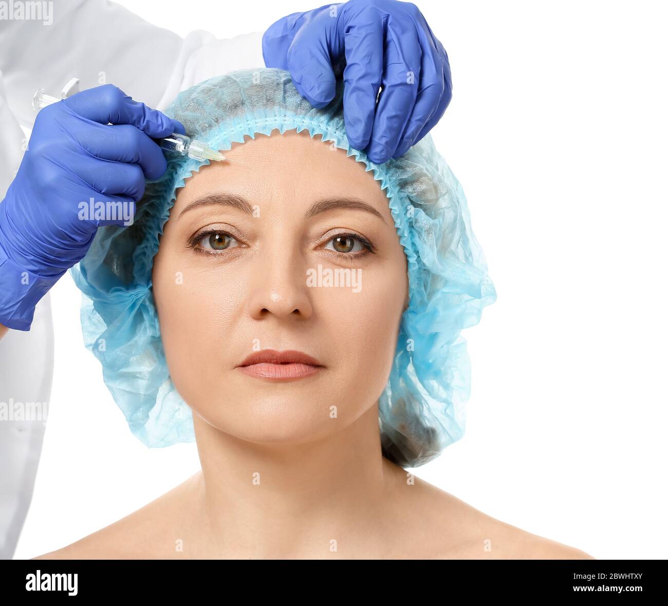 Woman receiving filler injection against white background Stock Photo ...