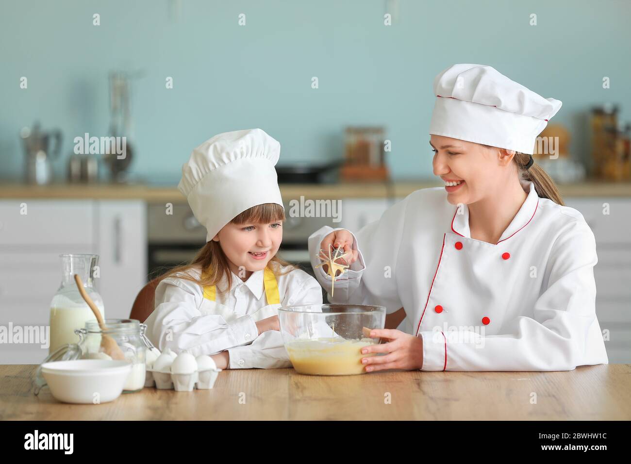 Female chef and her little daughter cooking in kitchen Stock Photo - Alamy