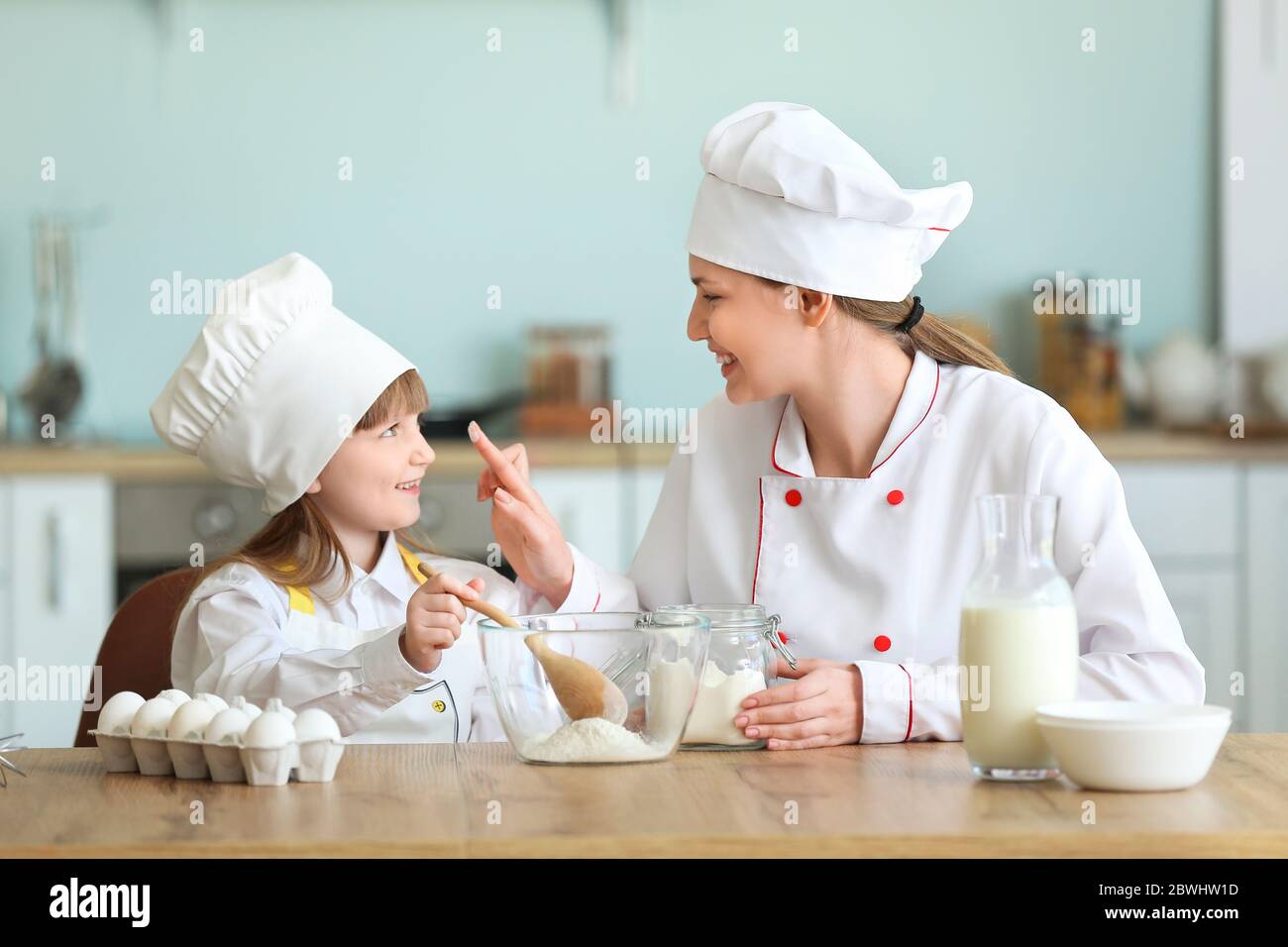 Female chef and her little daughter cooking in kitchen Stock Photo - Alamy