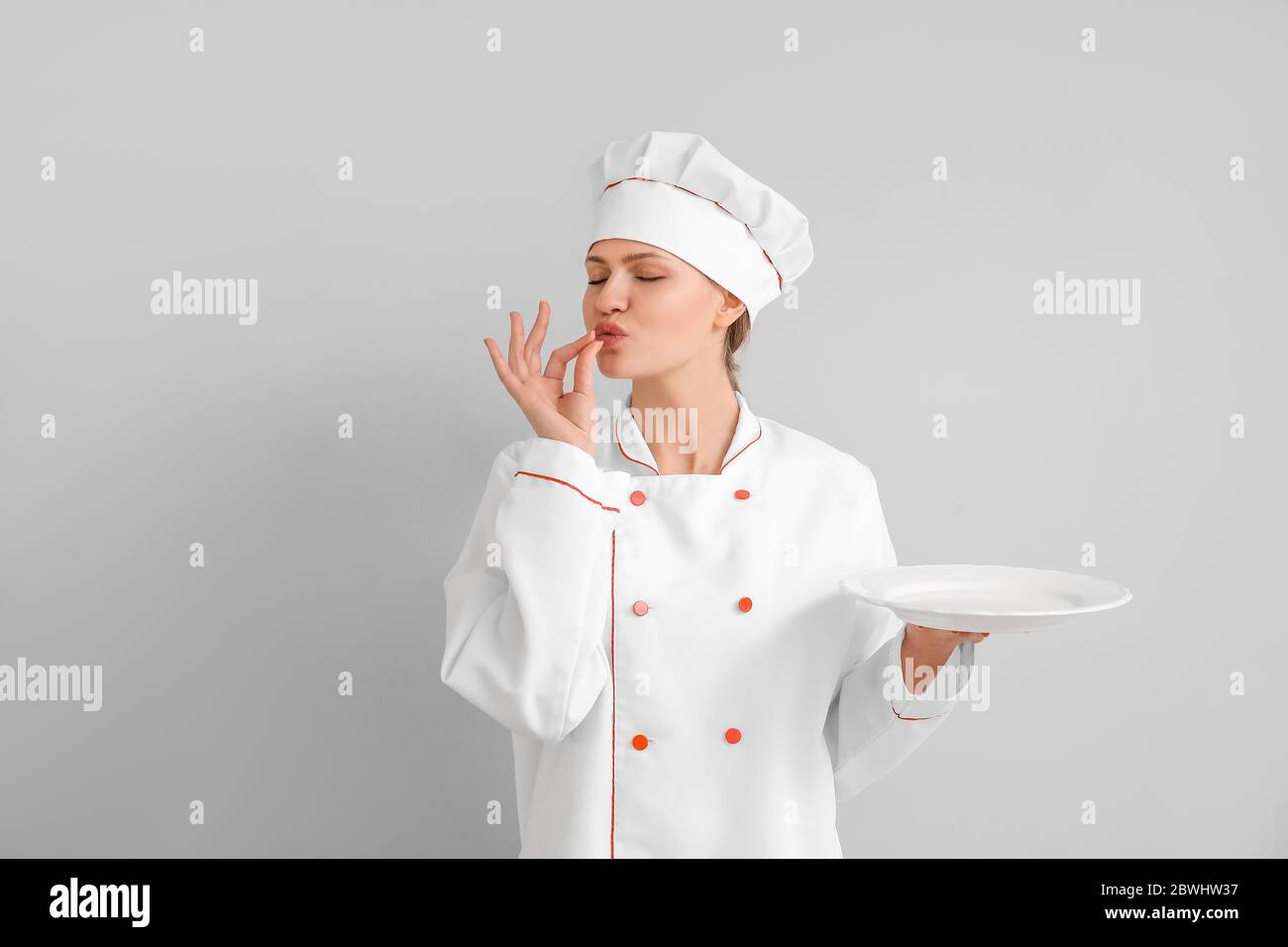 Beautiful female chef on light background Stock Photo - Alamy