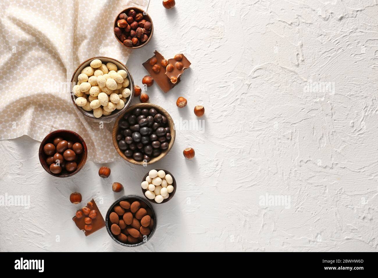 Different tasty chocolate nuts on white background Stock Photo - Alamy