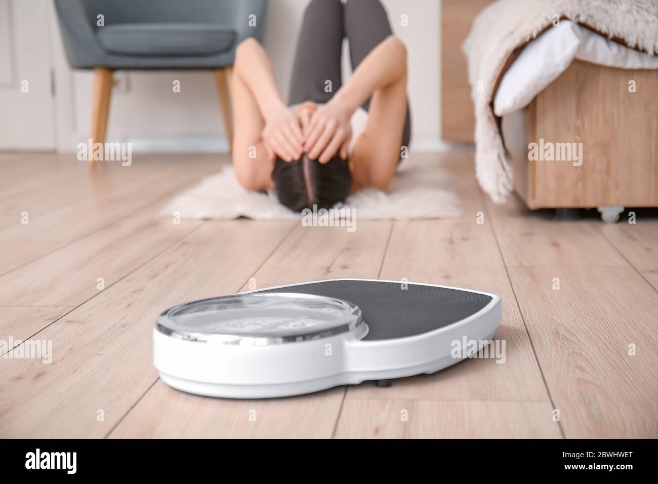 Measuring scales and depressed young woman lying on floor Stock Photo ...