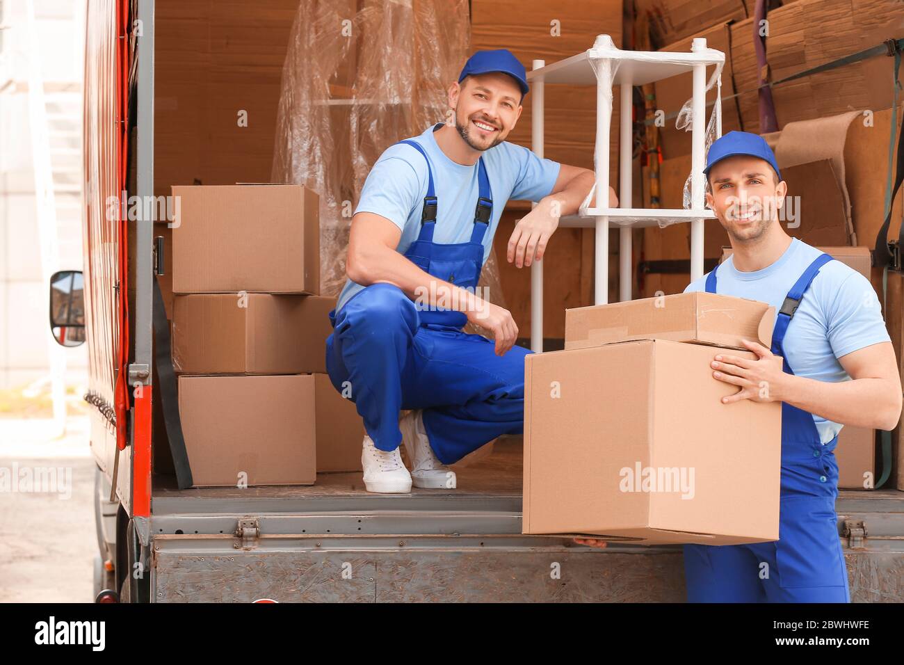 Male loaders carrying box hi-res stock photography and images - Alamy