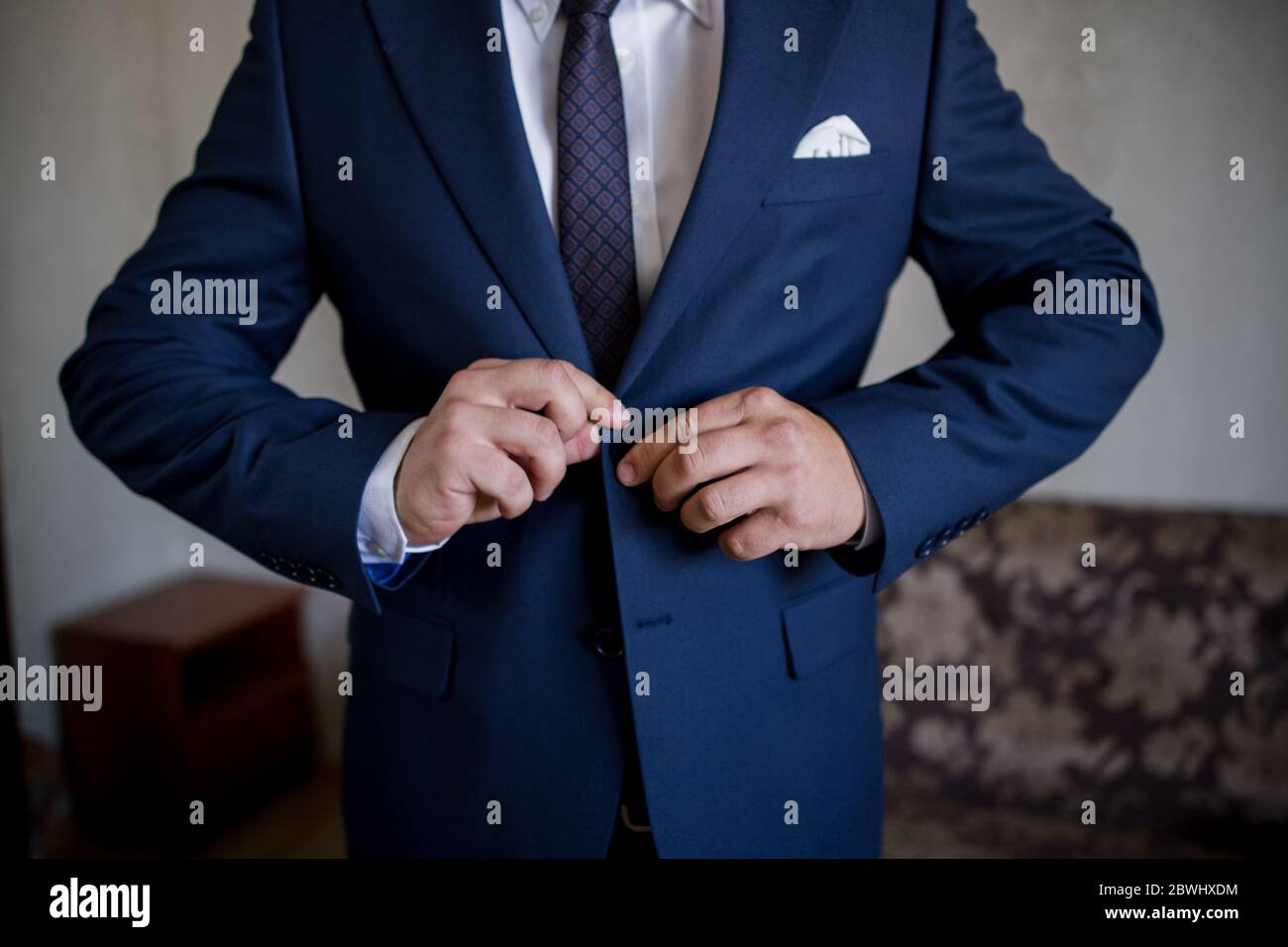 man puts on blue suit Stock Photo - Alamy