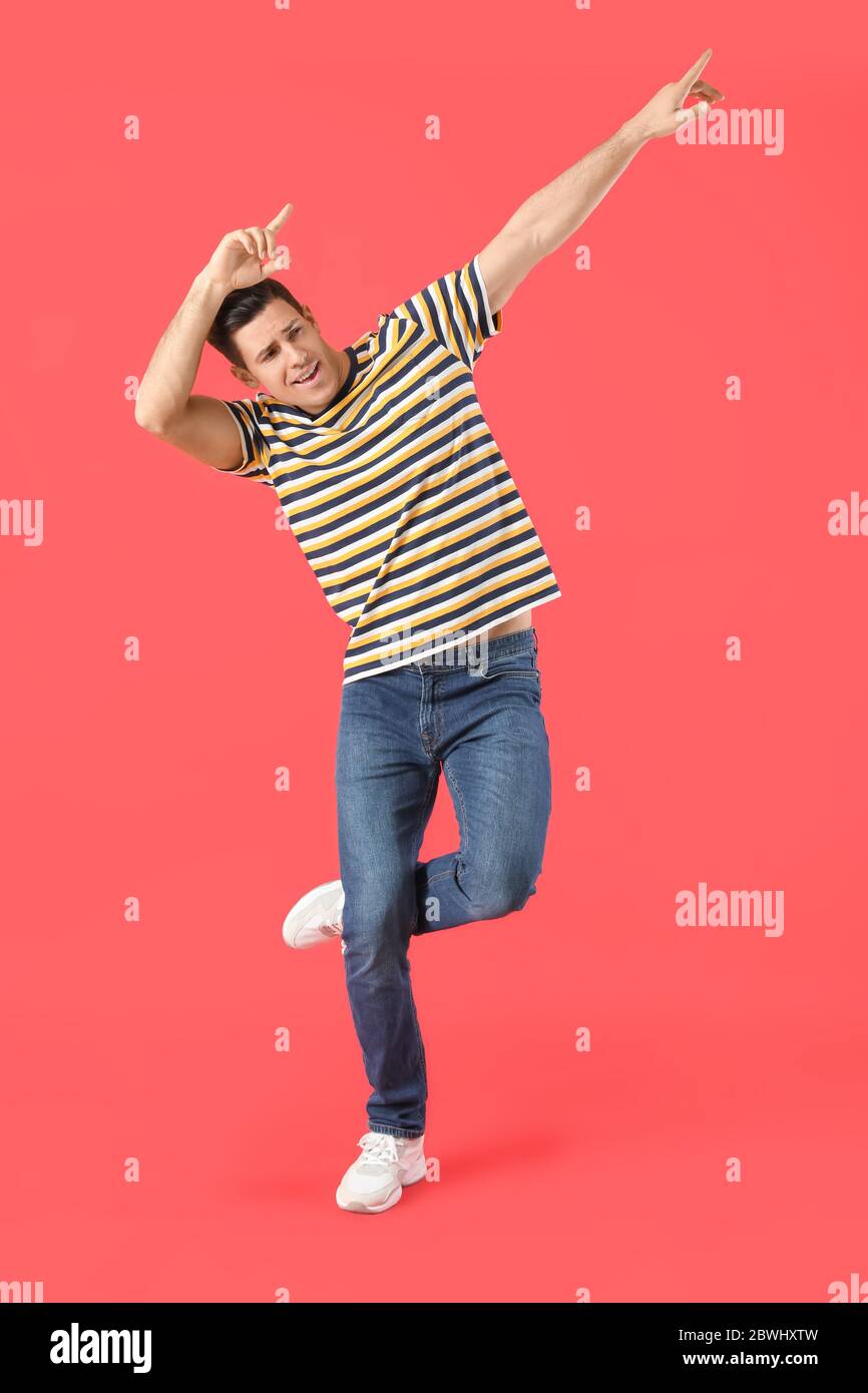 Handsome young man dancing against color background Stock Photo - Alamy
