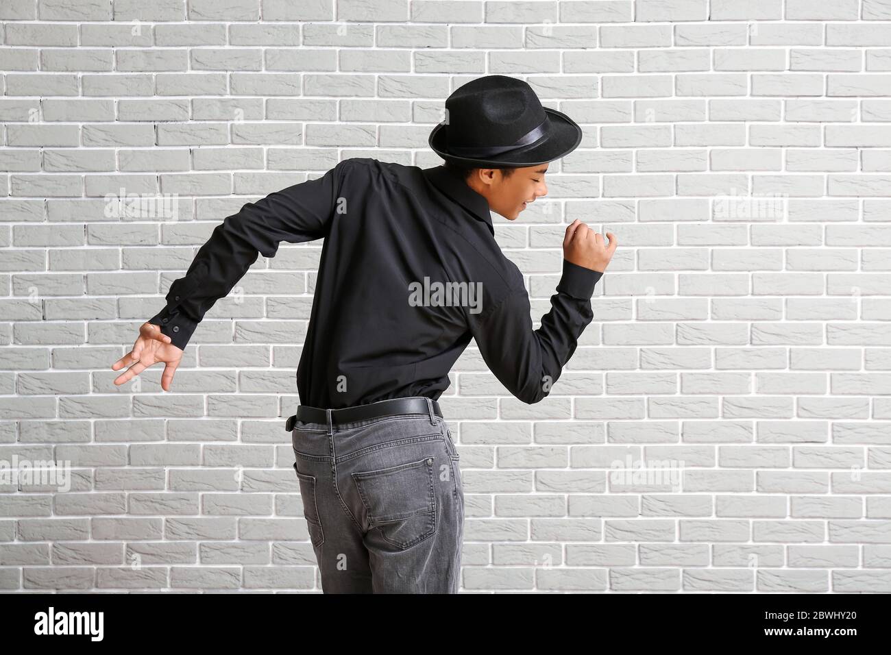 African-American teenager dancing against brick background Stock Photo ...