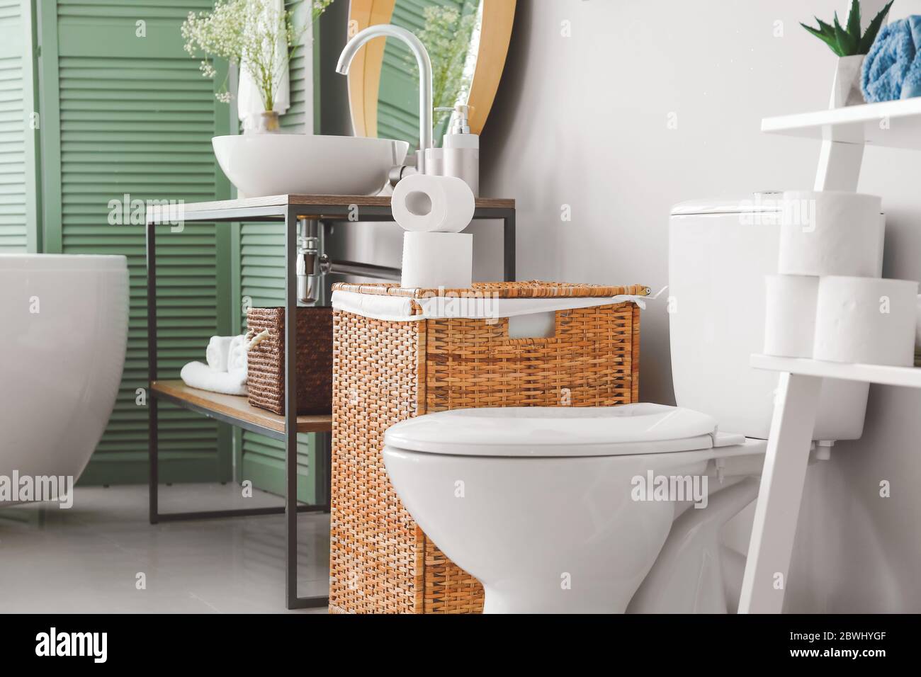 Toilet bowl and rolls of paper in restroom Stock Photo - Alamy