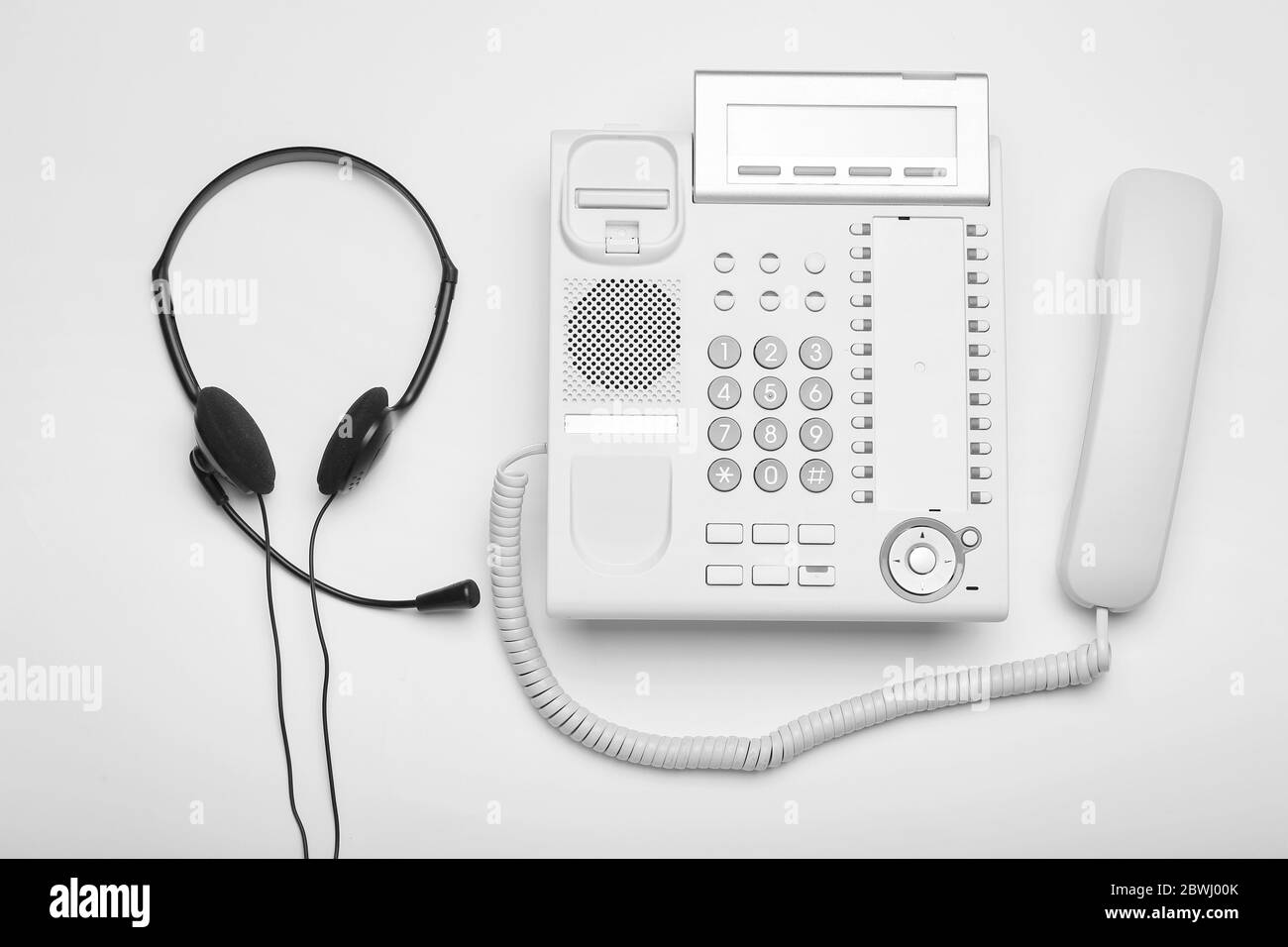 Headset and telephone on white background Stock Photo - Alamy