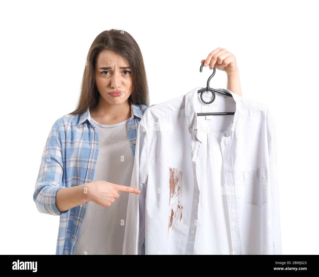 Displeased young woman with dirty clothes on white background Stock ...