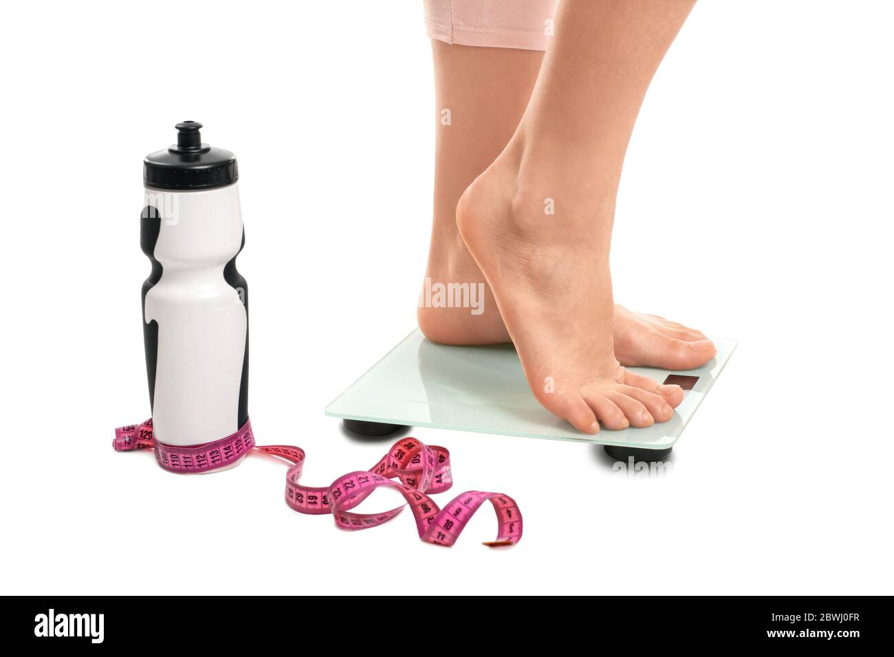 Young woman measuring her weight against white background Stock Photo ...