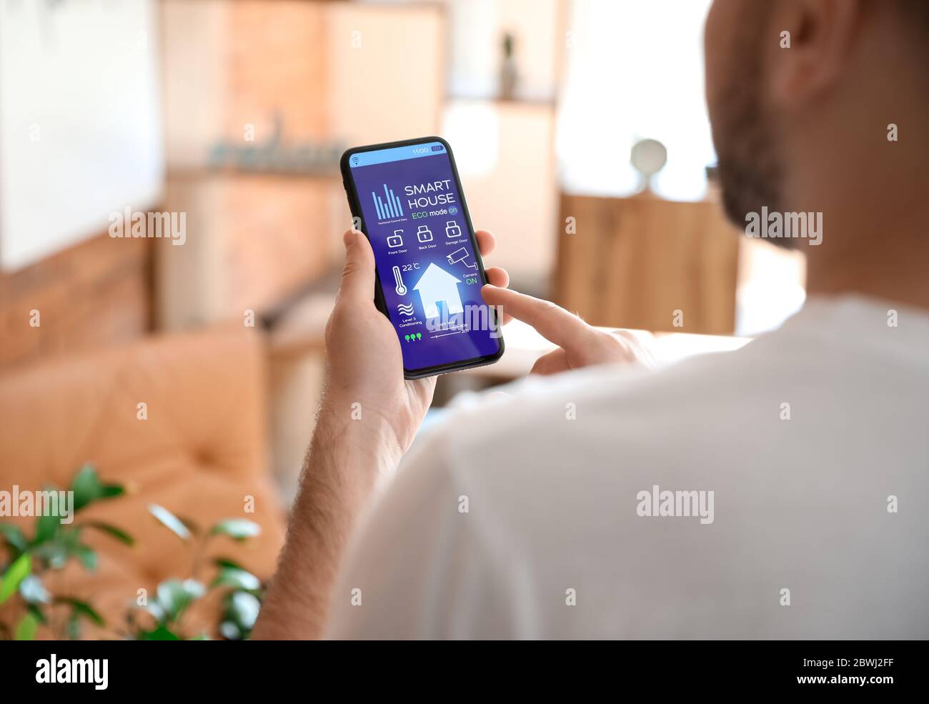 Man using application of smart home automation Stock Photo - Alamy