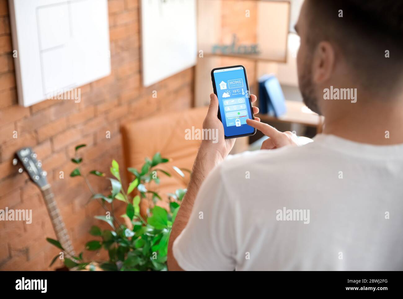 Man using application of smart home automation Stock Photo - Alamy