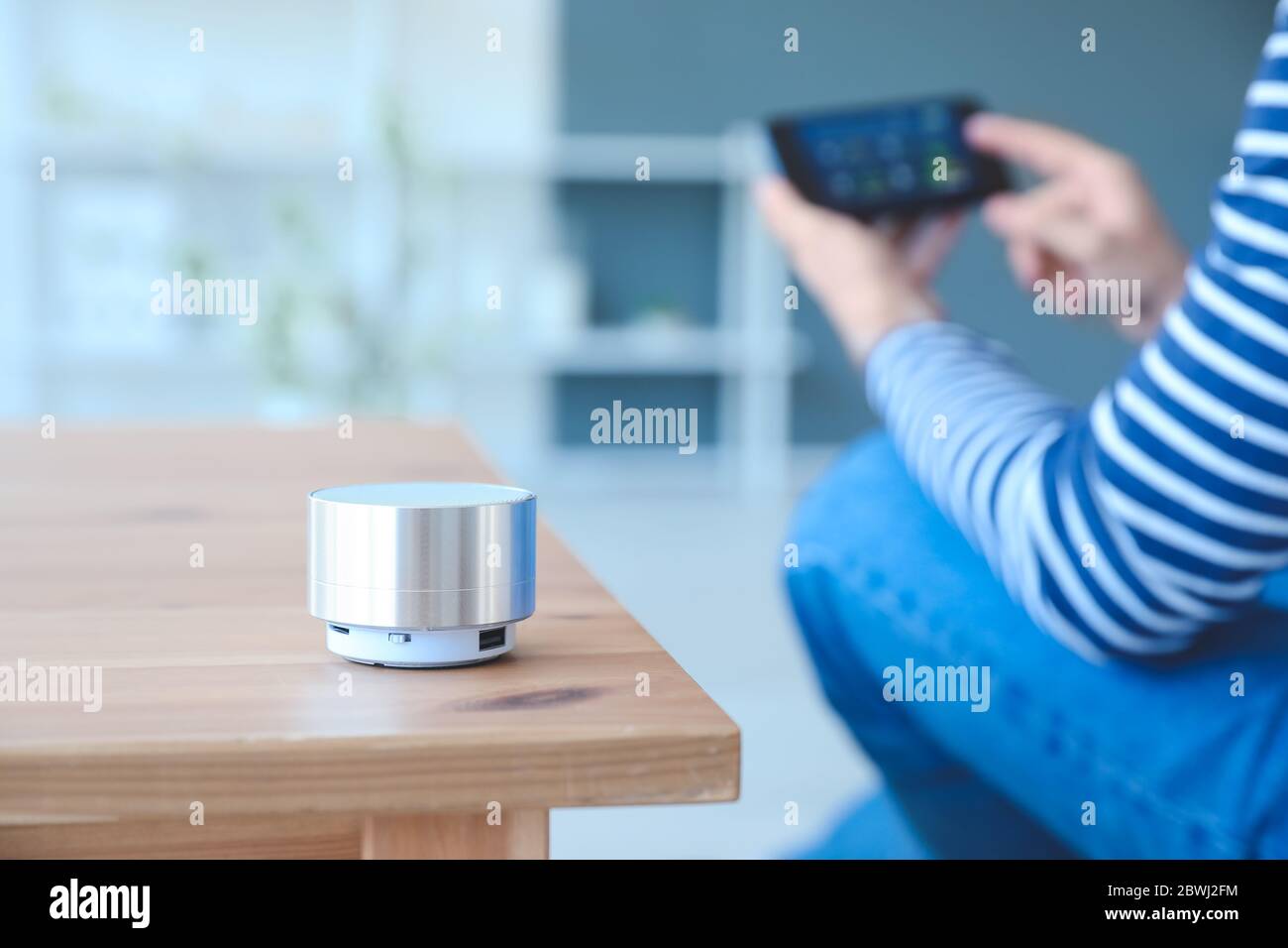 Young man with smart home assistant device in room Stock Photo - Alamy