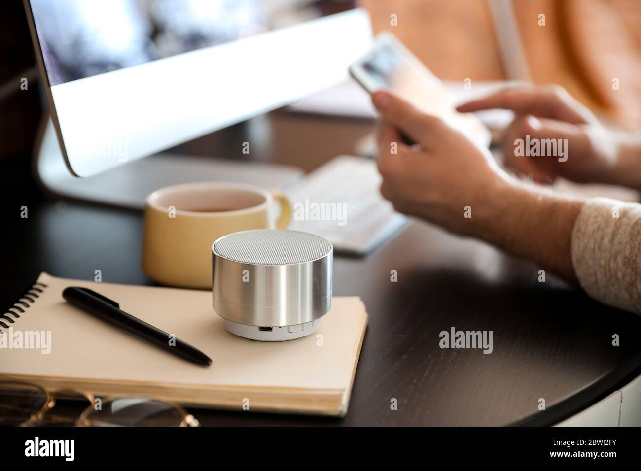 Smart home assistant device with notebook and pen on table in room ...