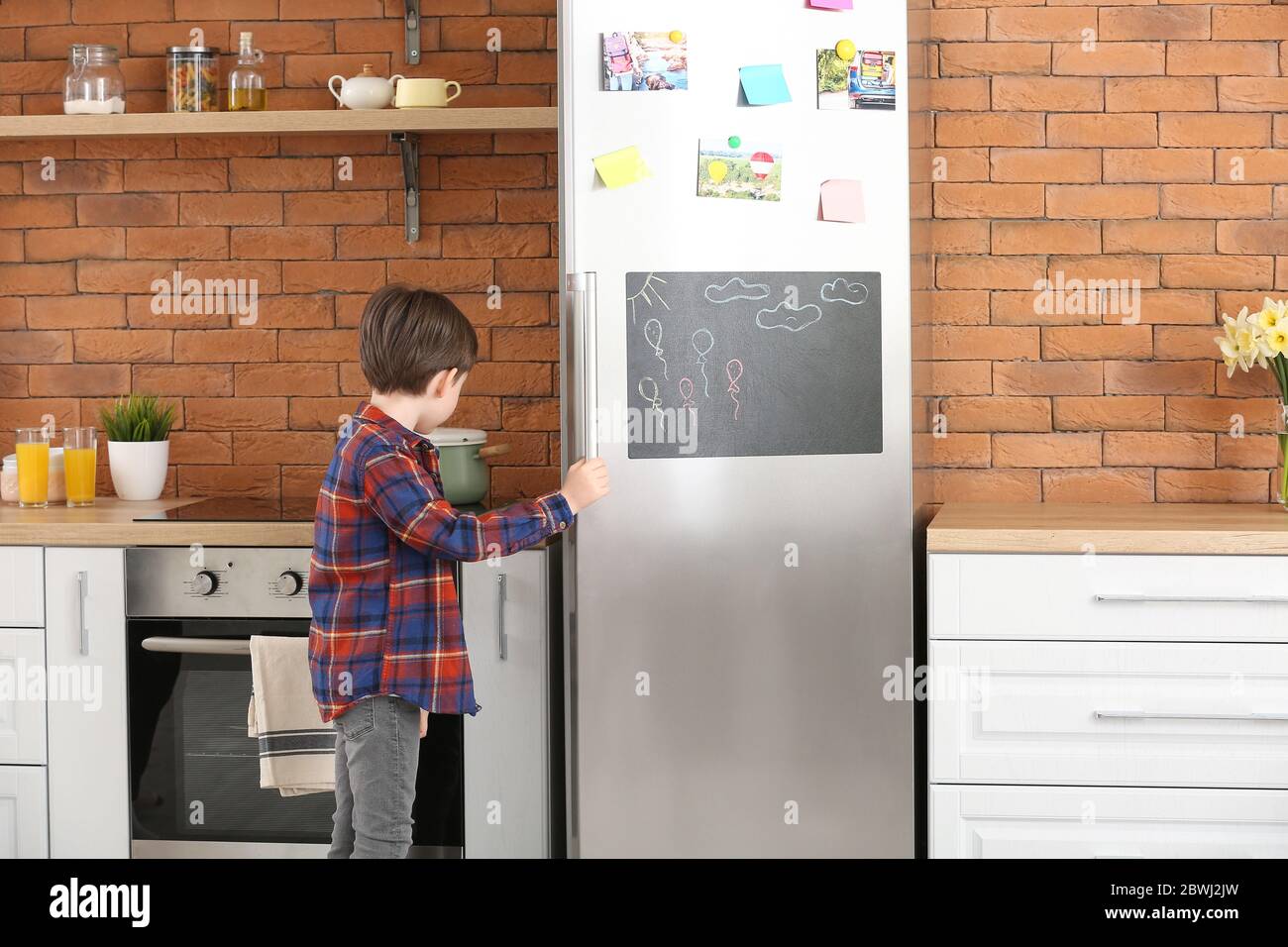 Little boy opening refrigerator in kitchen Stock Photo - Alamy