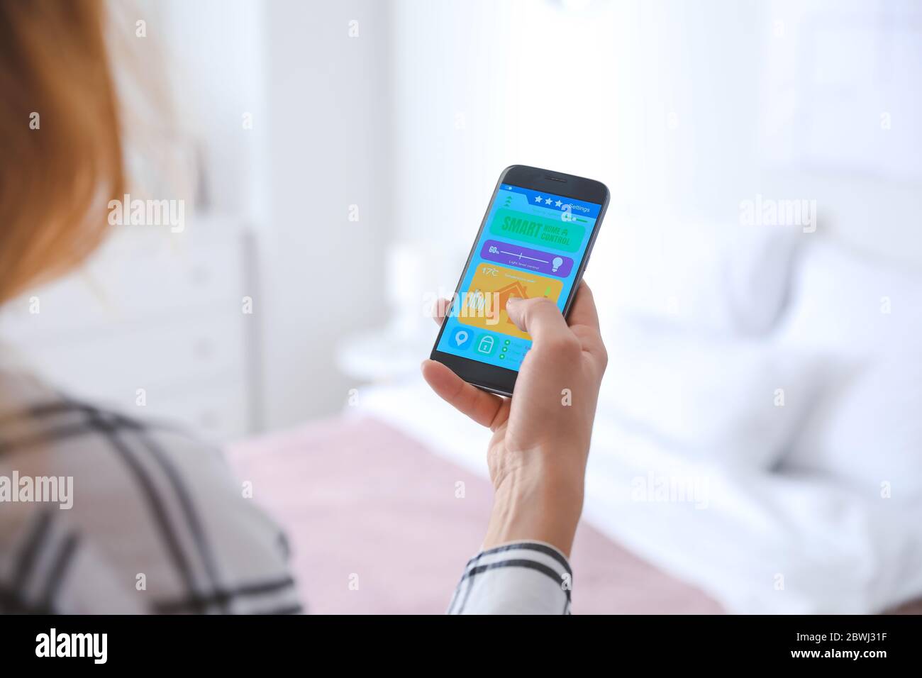 Woman using application of smart home automation Stock Photo - Alamy