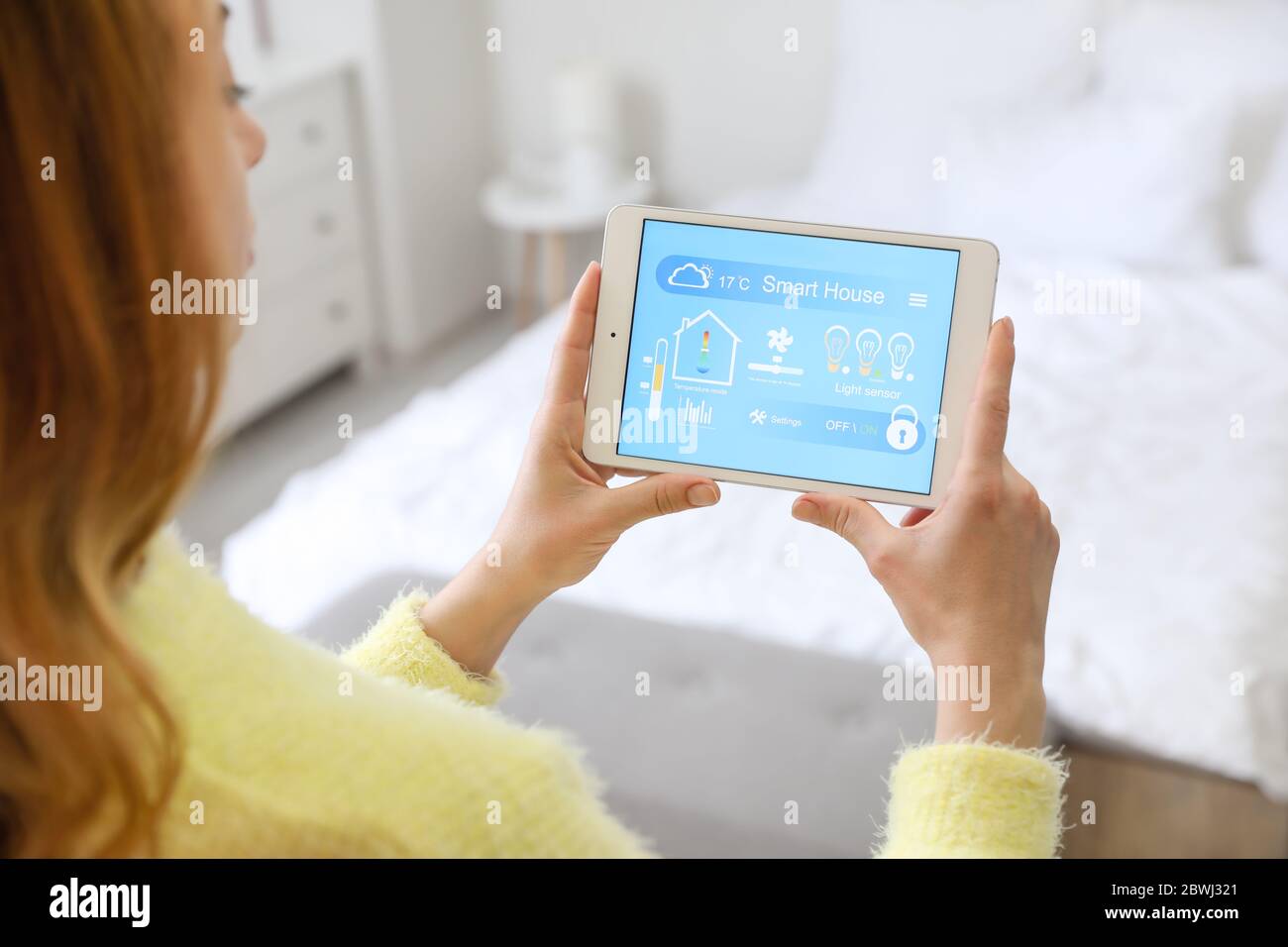 Woman using application of smart home automation Stock Photo - Alamy