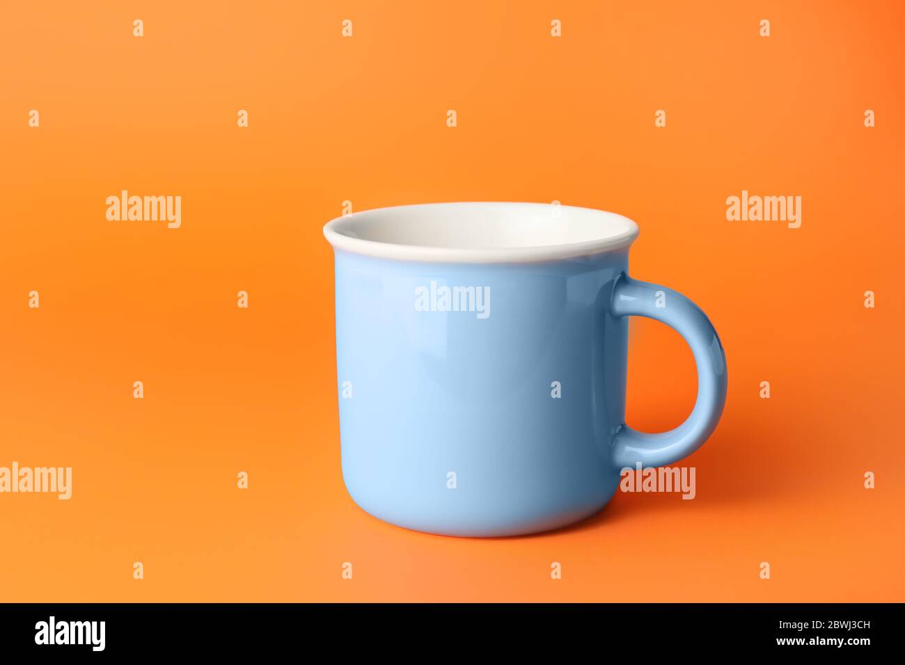 Blank cup on color background Stock Photo - Alamy