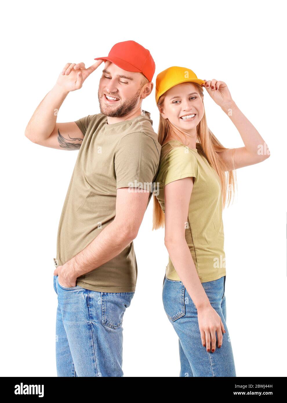 Young couple in stylish caps on white background Stock Photo - Alamy