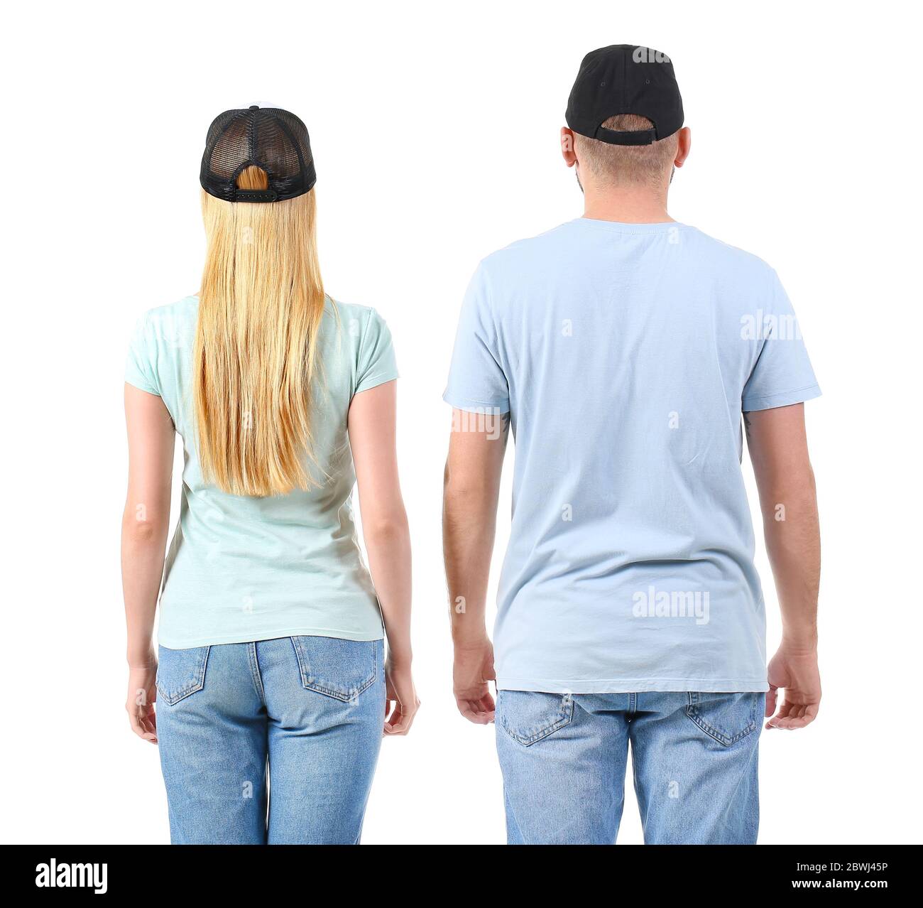 Young couple in stylish caps on white background, back view Stock Photo ...