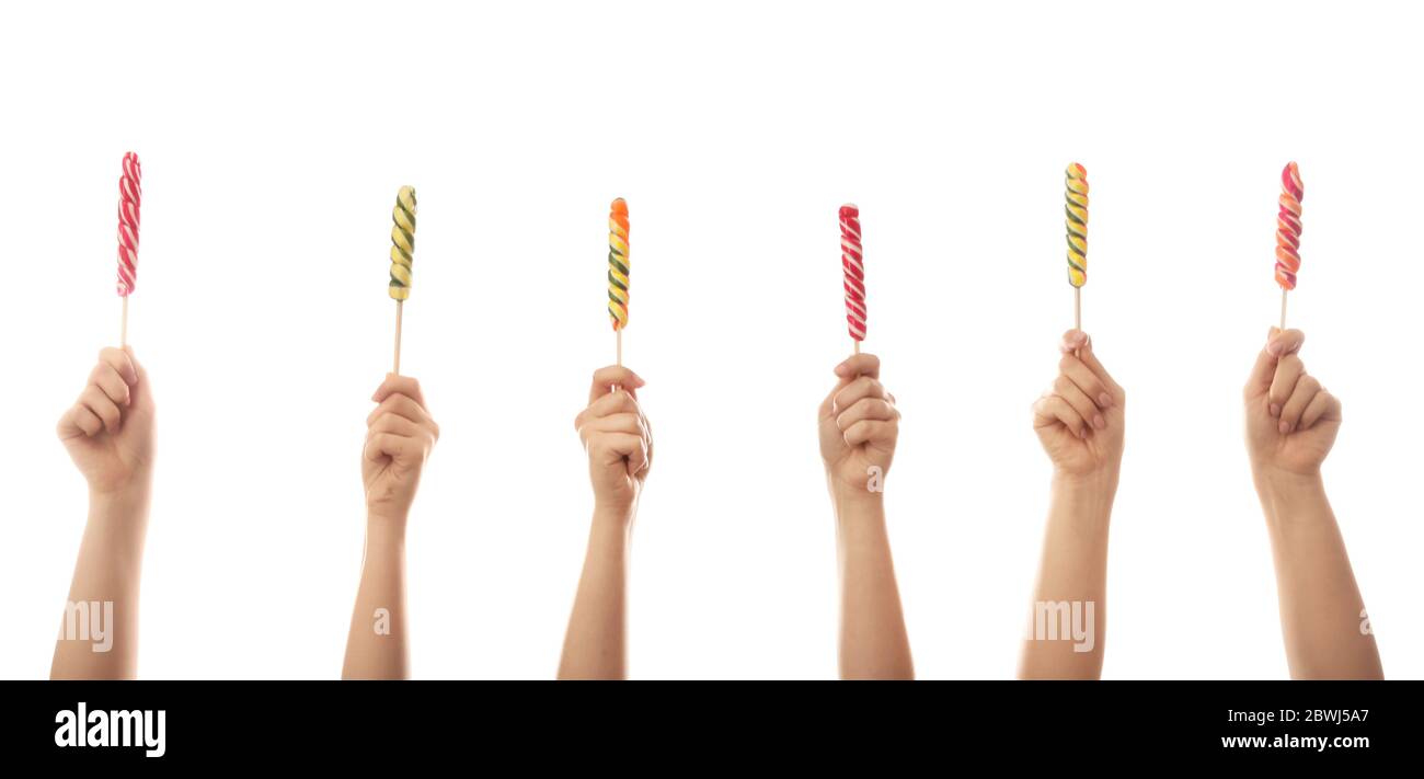 Hands with sweet lollipops on white background Stock Photo - Alamy