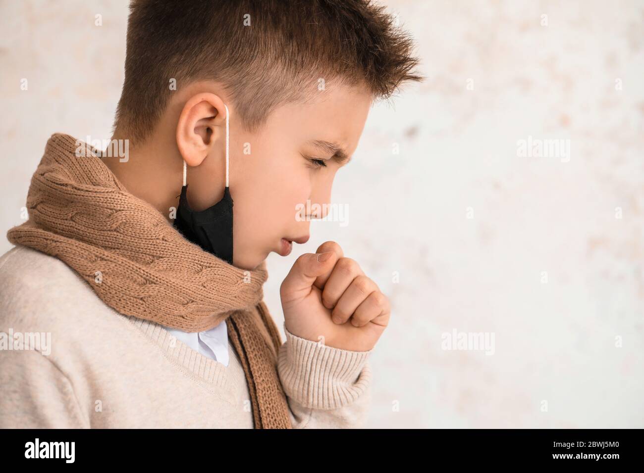 Ill coughing little boy on light background Stock Photo - Alamy