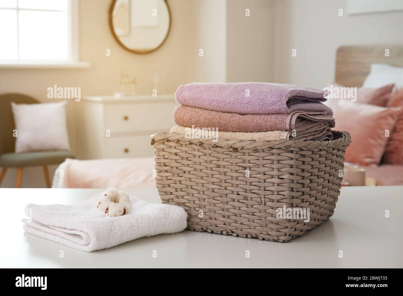 Basket with laundry on table in room Stock Photo - Alamy