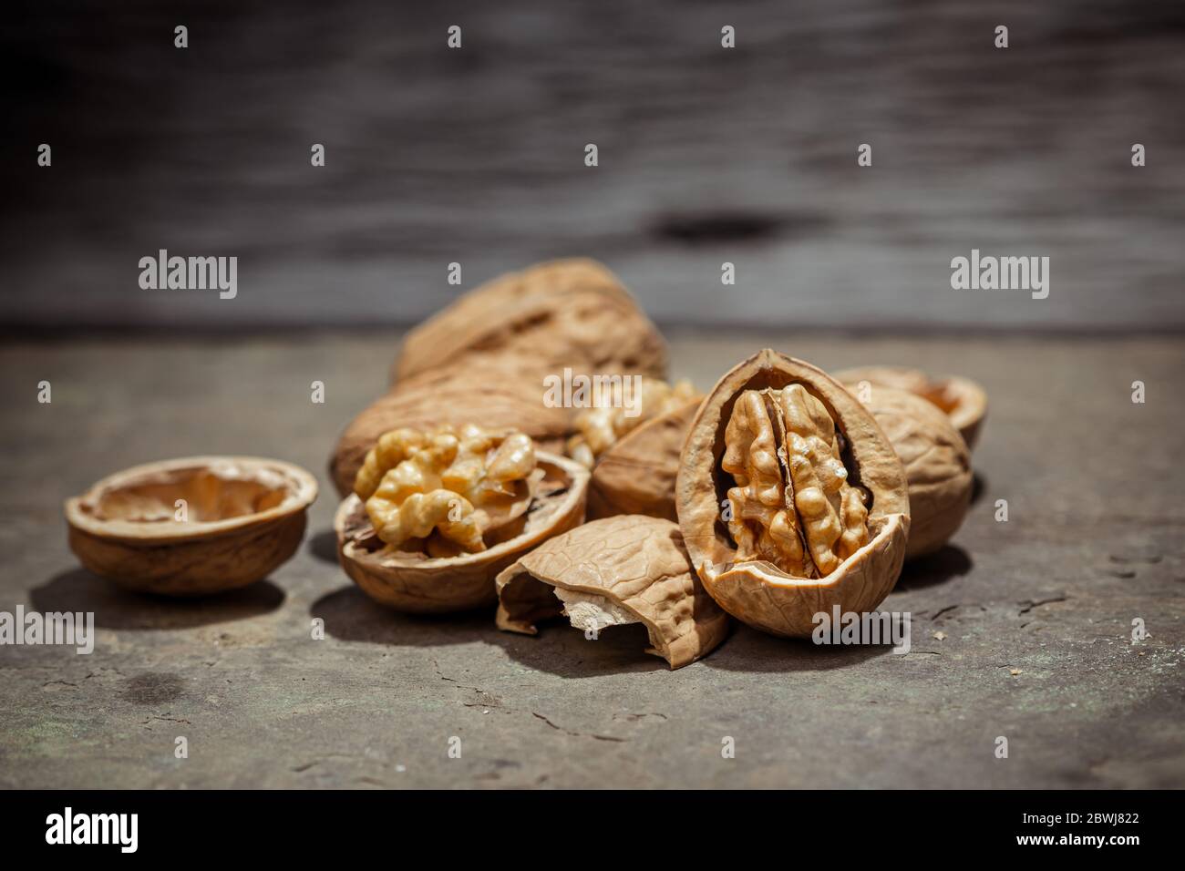 still life with Walnut kernels and whole walnuts on rustic old wooden ...