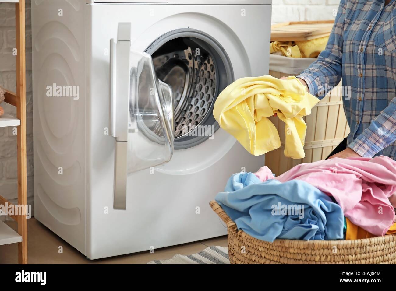 Young woman doing laundry at home Stock Photo - Alamy
