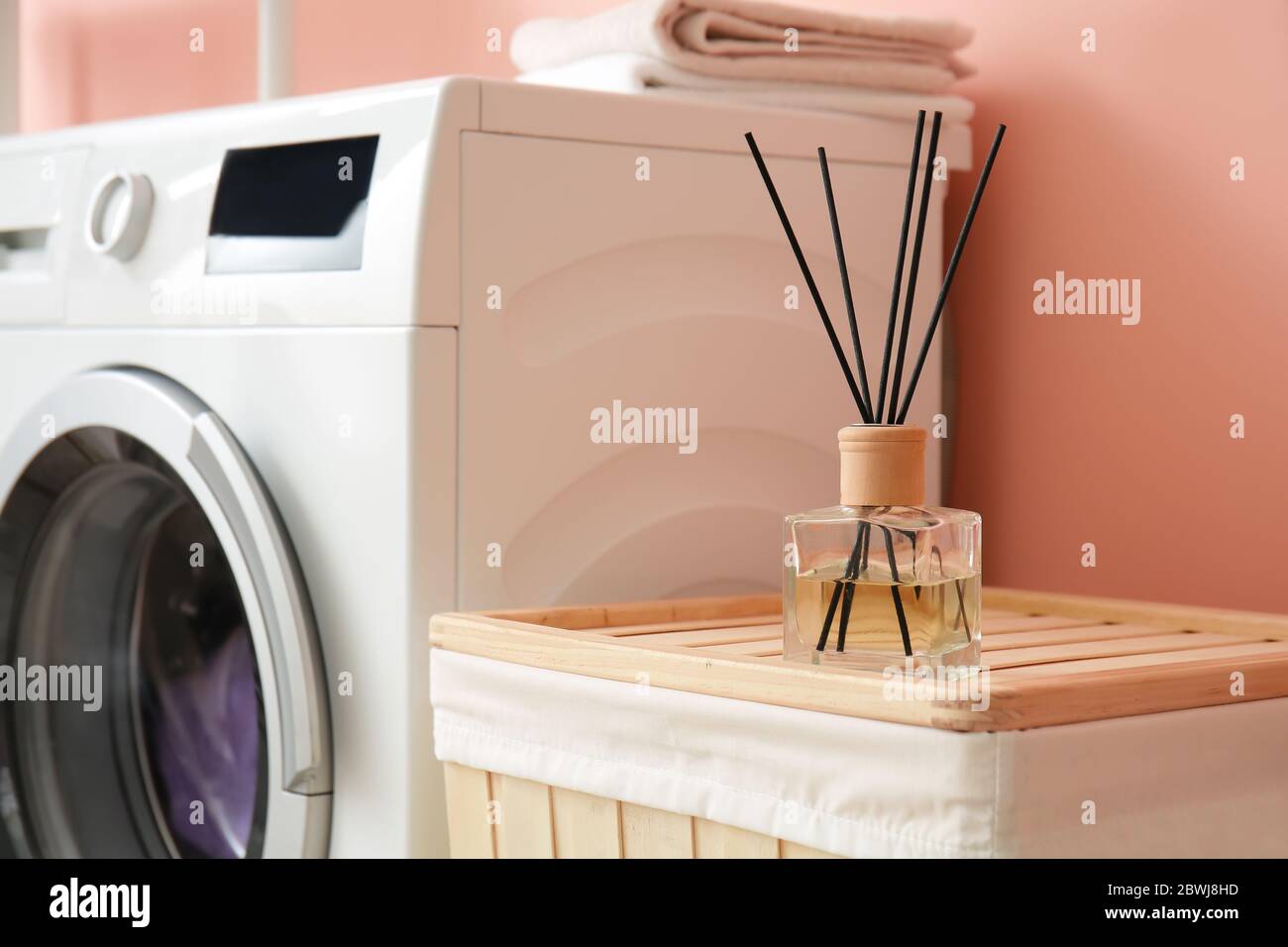 Reed diffuser on laundry basket in bathroom Stock Photo - Alamy