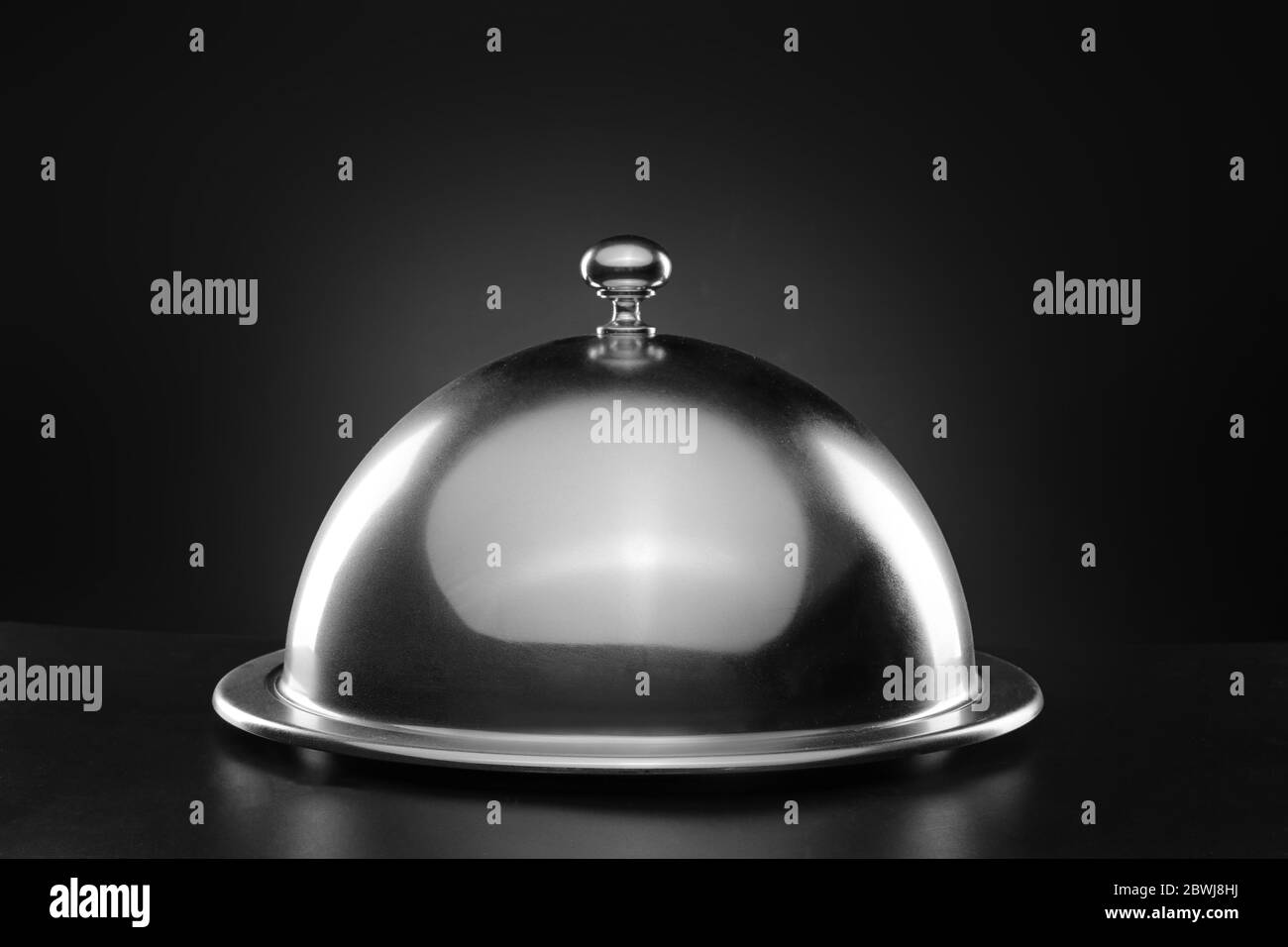 Tray and cloche on dark background Stock Photo - Alamy