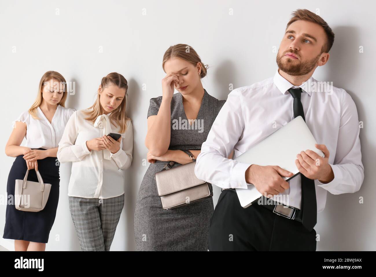 Business people waiting in line indoors Stock Photo - Alamy