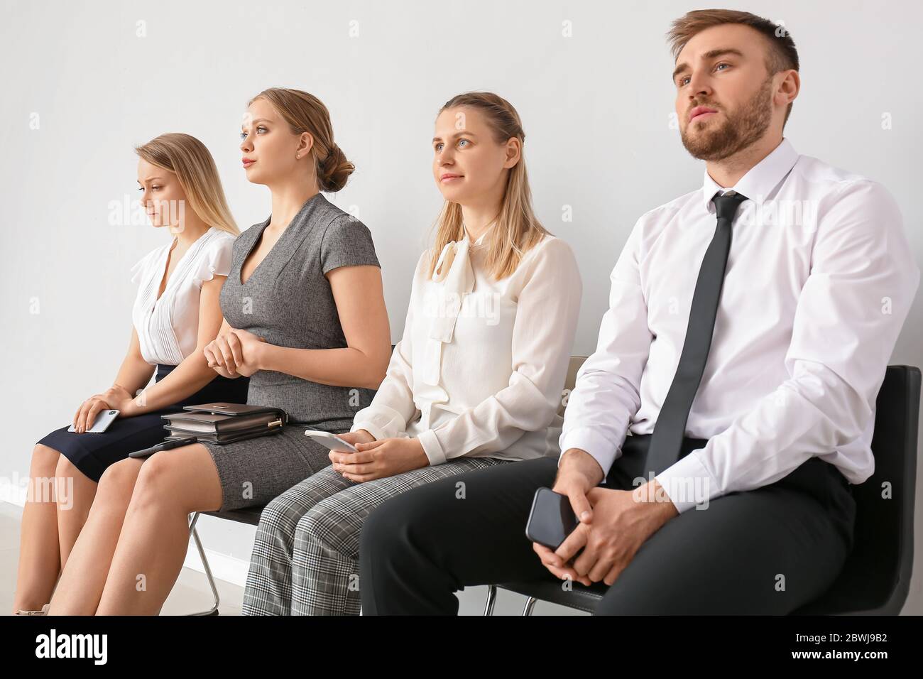 Business people waiting in line indoors Stock Photo - Alamy