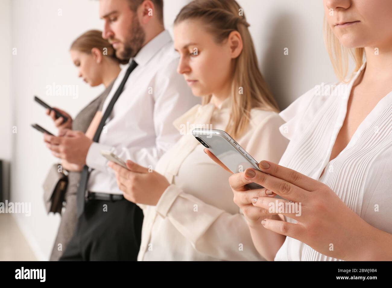 Business people waiting in line indoors Stock Photo - Alamy