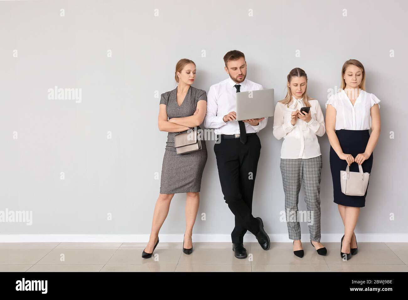 Business people waiting in line indoors Stock Photo - Alamy
