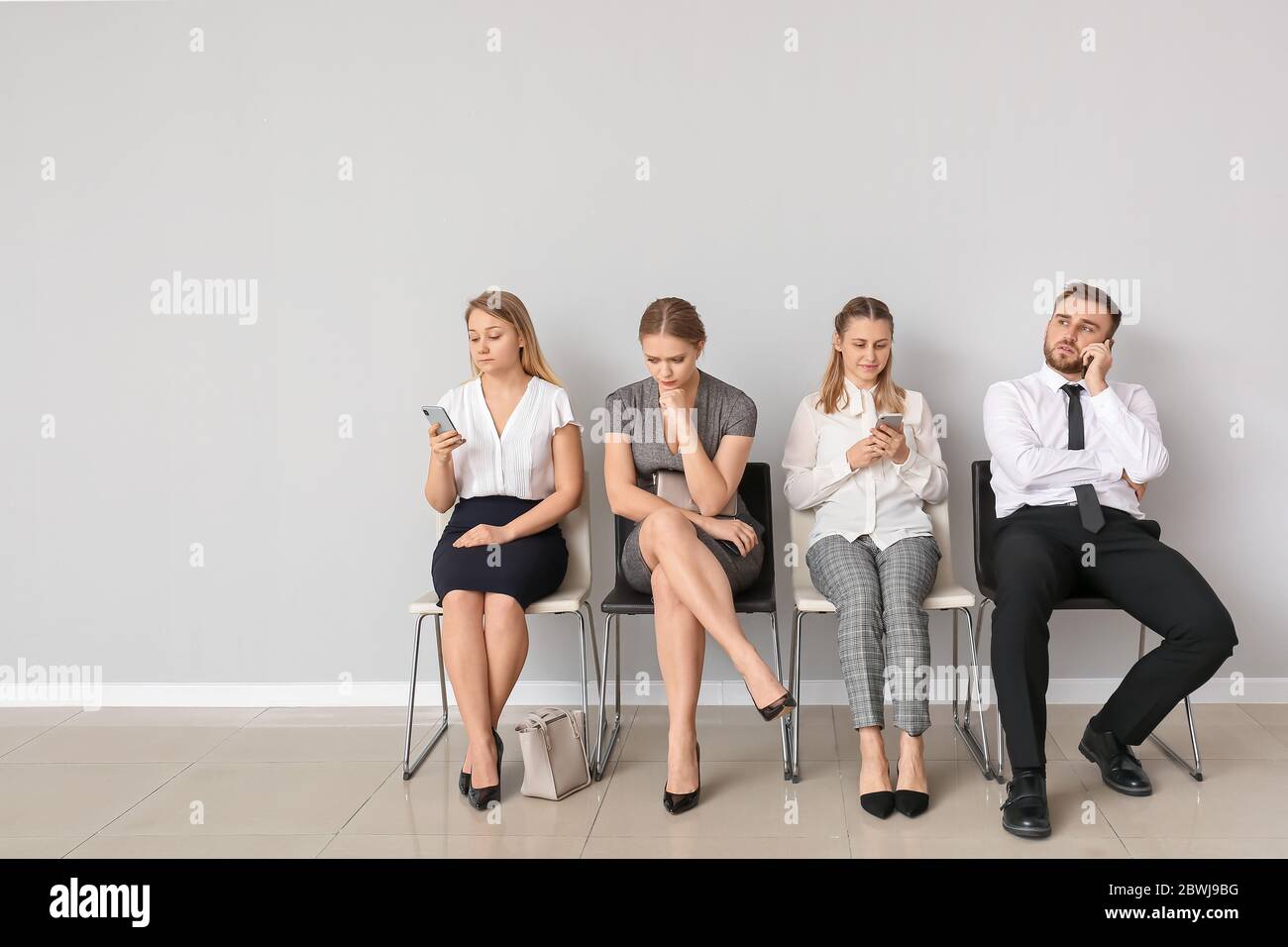 Business people waiting in line indoors Stock Photo - Alamy