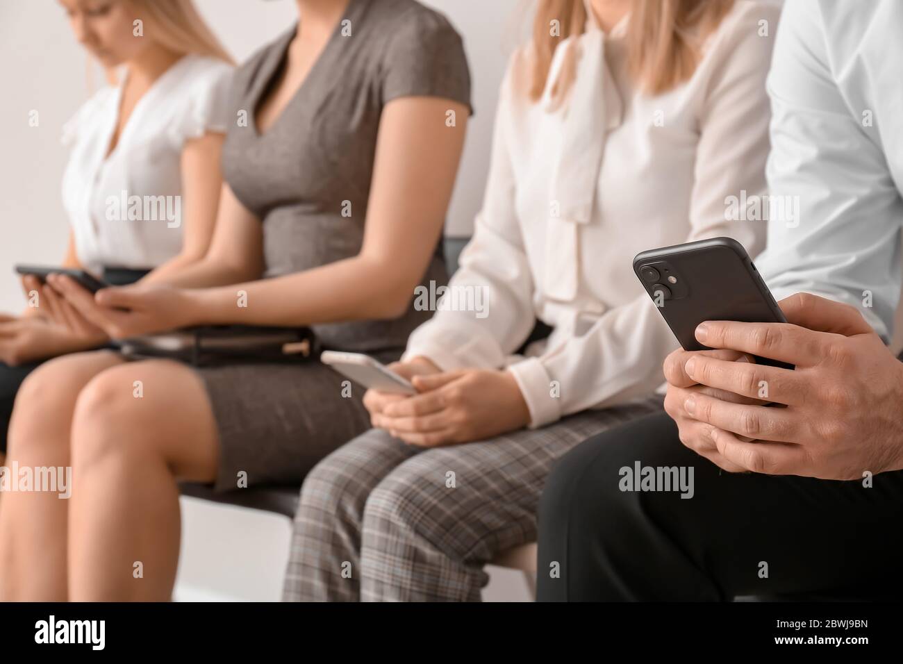 Business people waiting in line indoors Stock Photo - Alamy