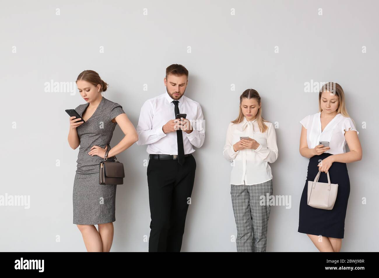 Business people waiting in line indoors Stock Photo - Alamy