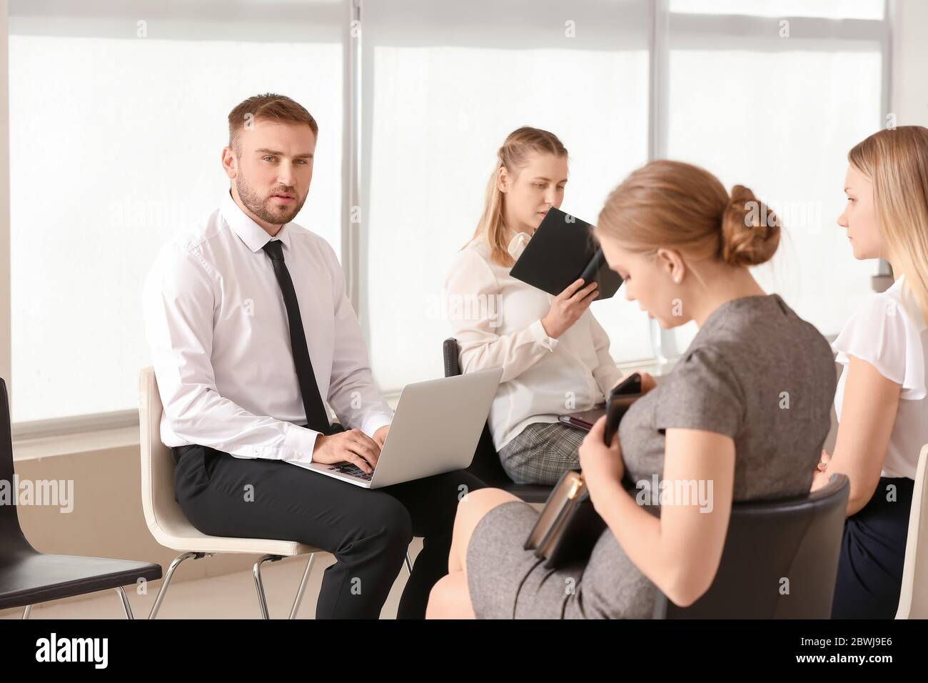 Business people waiting in line indoors Stock Photo - Alamy