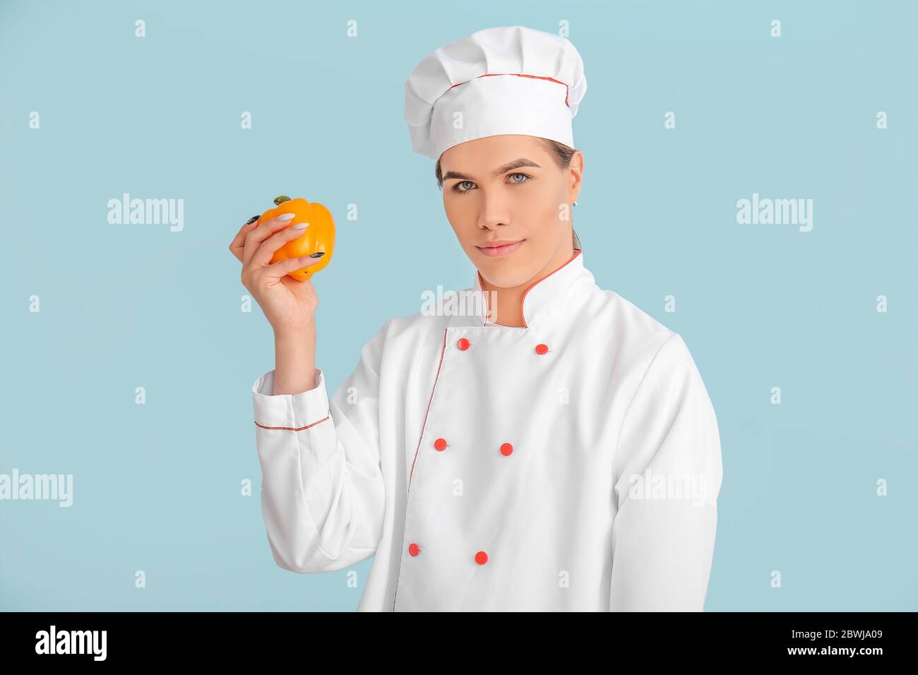 Transgender chef with bell pepper on color background Stock Photo - Alamy