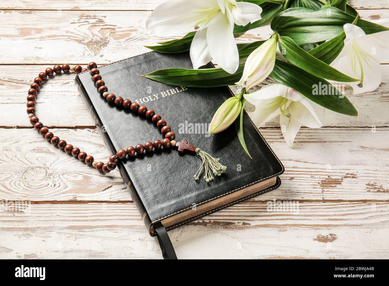 Holy Bible, rosary beads and flowers on wooden background Stock Photo ...