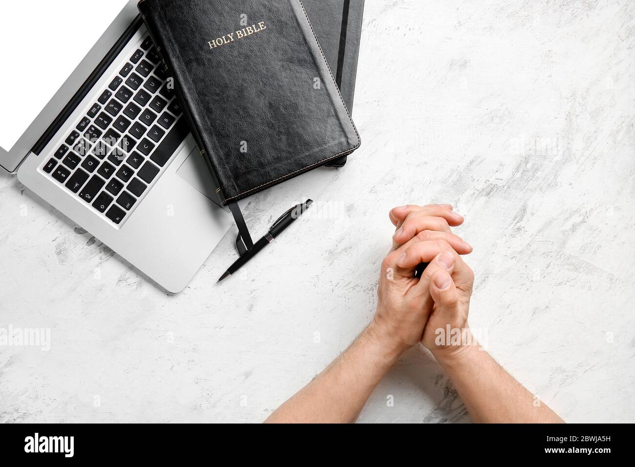 Religious man praying at table, top view Stock Photo - Alamy